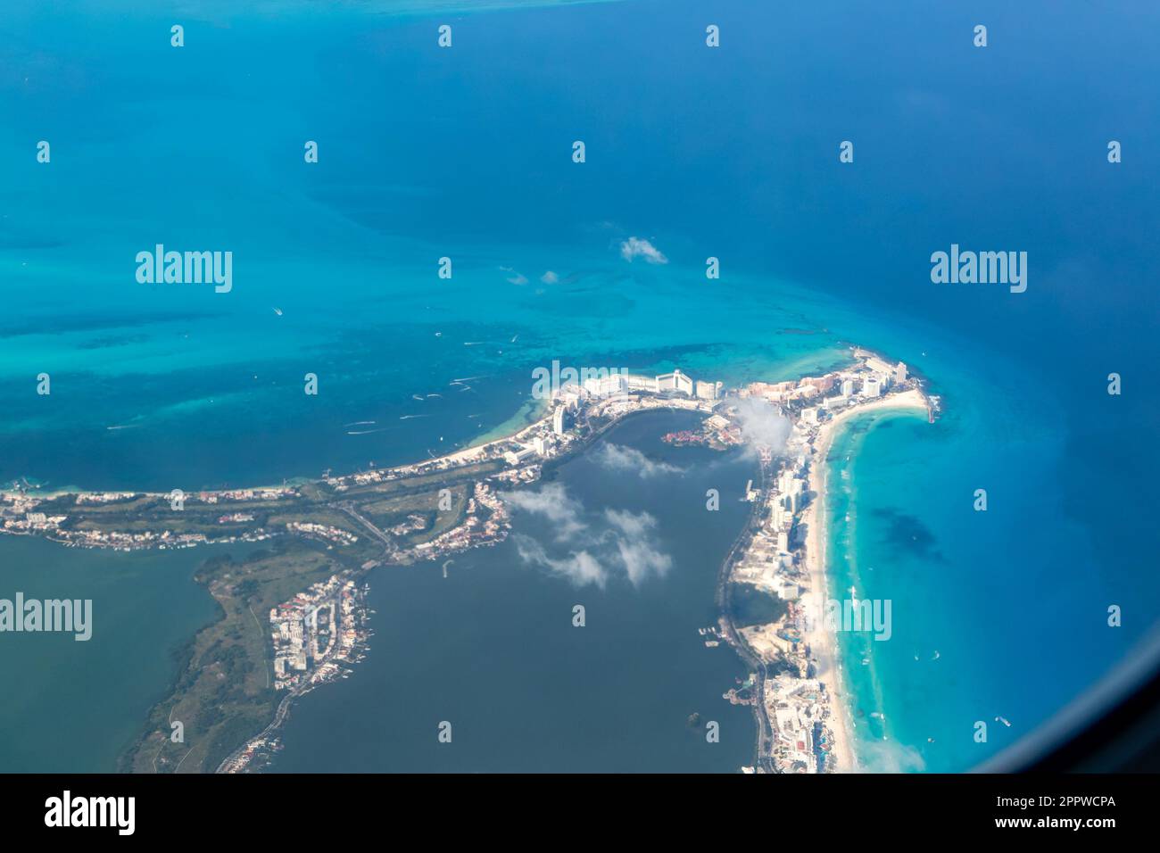 Aerial view through plane window of Caribbean coastline buildings in ...
