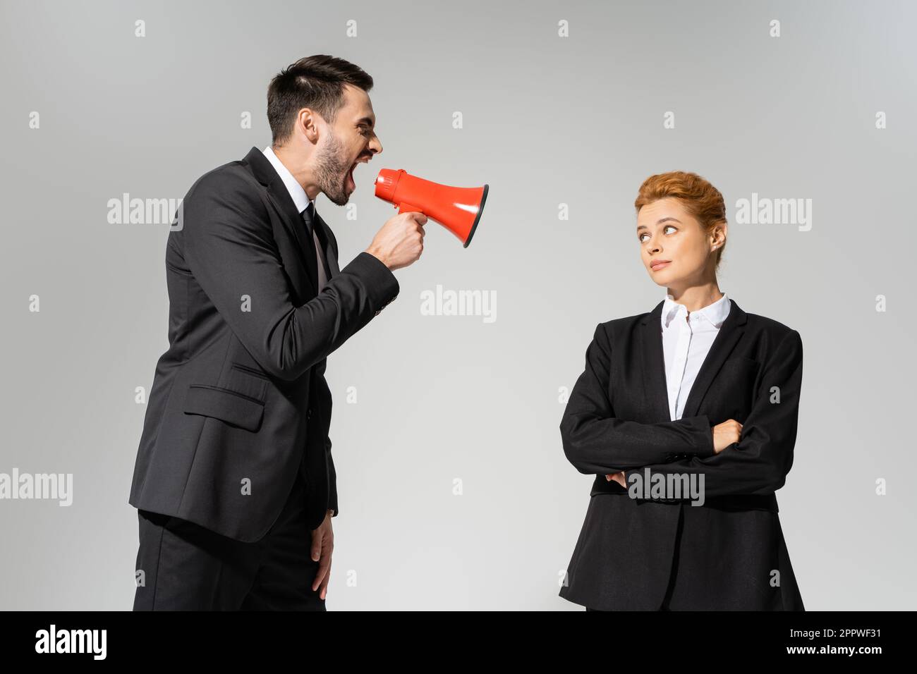 angry boss screaming in megaphone near indifferent redhead employee ...
