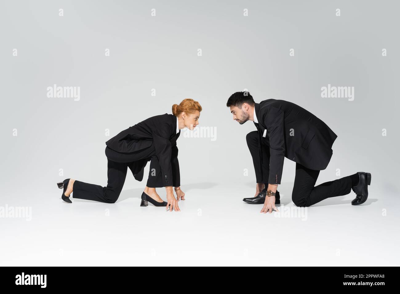 side view of business people in suits standing in low start position ...