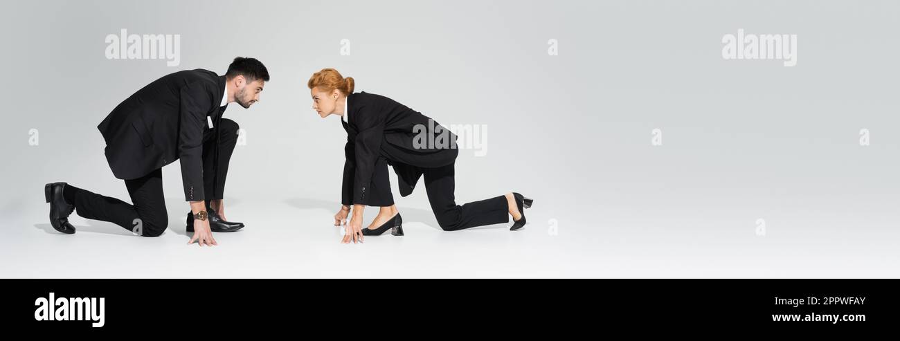 side view of business competitors in black suits looking at each other ...