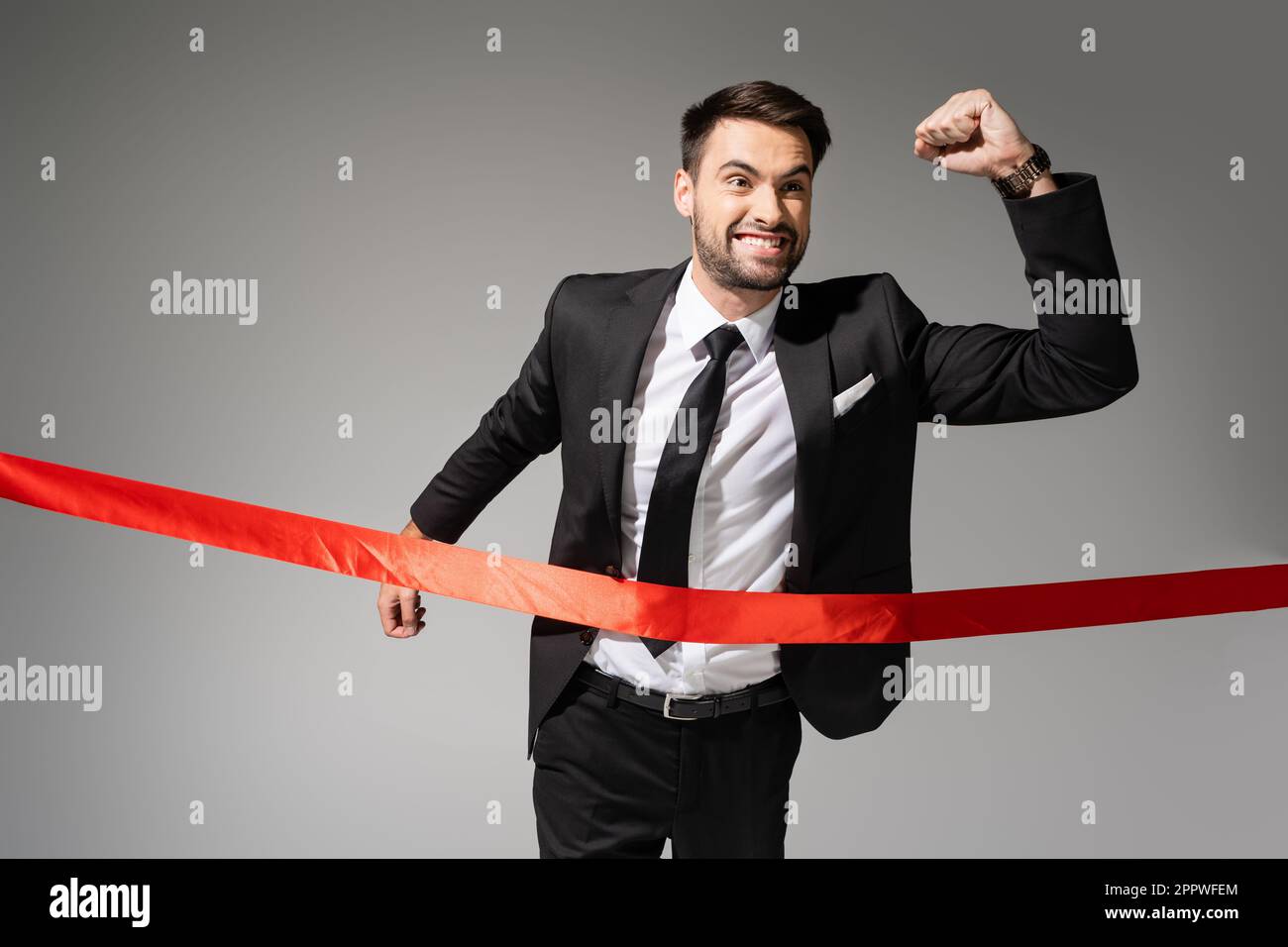 successful and excited businessman showing win gesture and crossing red ...