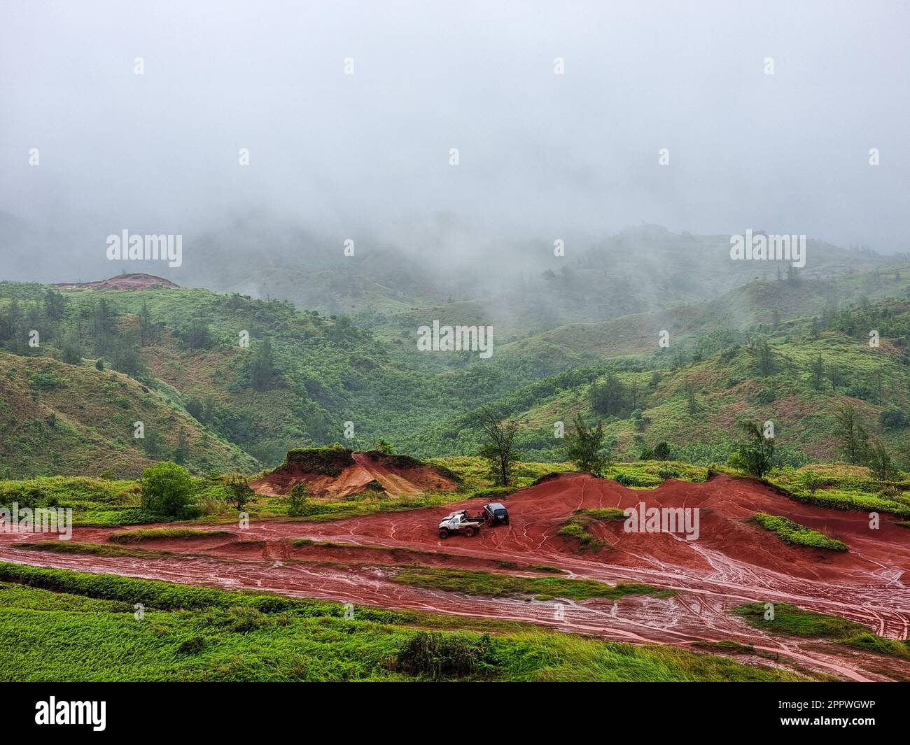 The three off-road cars in the valley surrounded by green mountains ...