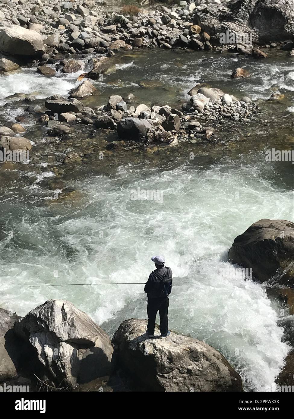 Overhead view of a man trout fishing in the Himalayas, Himachal Pradesh ...