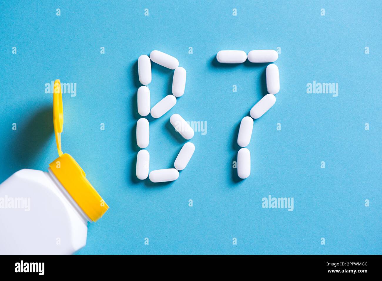 Vitamin B7, biotin supplement. White pills forming shape to B7 sign on ...