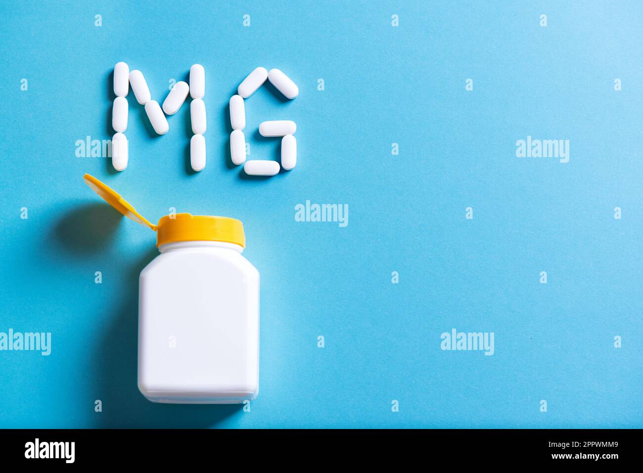 Mineral pill capsule Magnesium. White vitamin pills forming shape to Mg ...