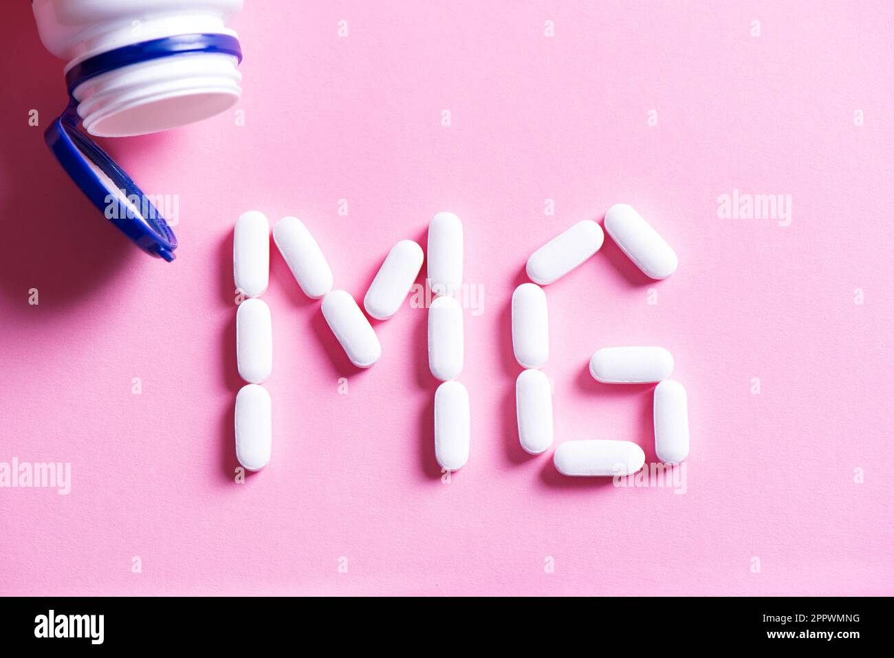 Mineral pill capsule Magnesium. White vitamin pills forming shape to Mg ...