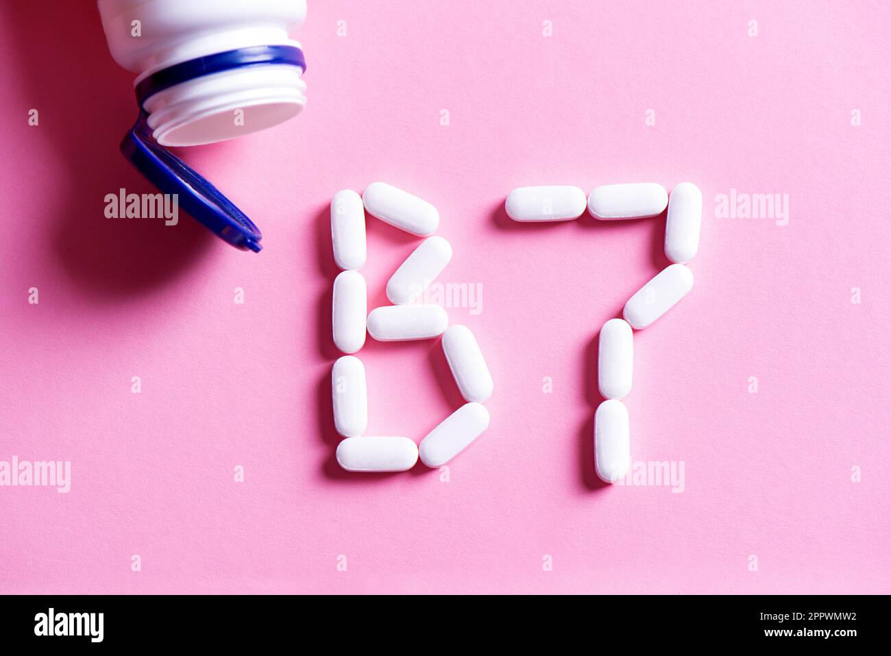 Vitamin B7, biotin supplement. White pills forming shape to B7 sign and ...