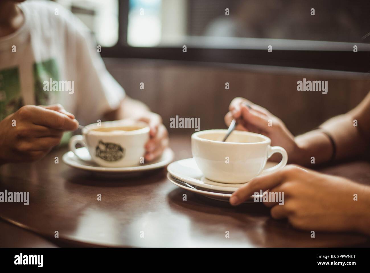Two people sitting in a cafe drinking coffee Stock Photo - Alamy