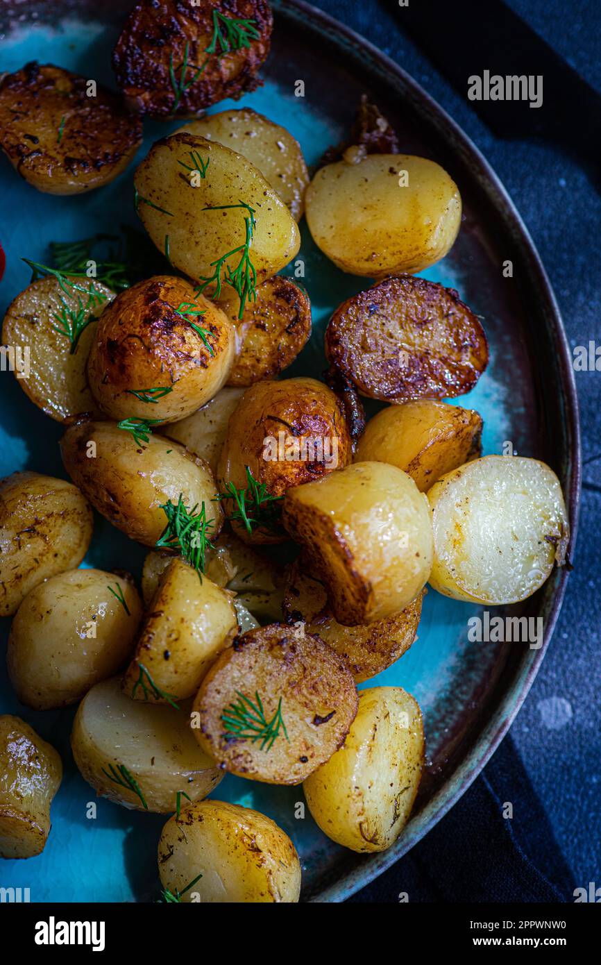 Plate of roasted new potatoes with fresh dill Stock Photo - Alamy