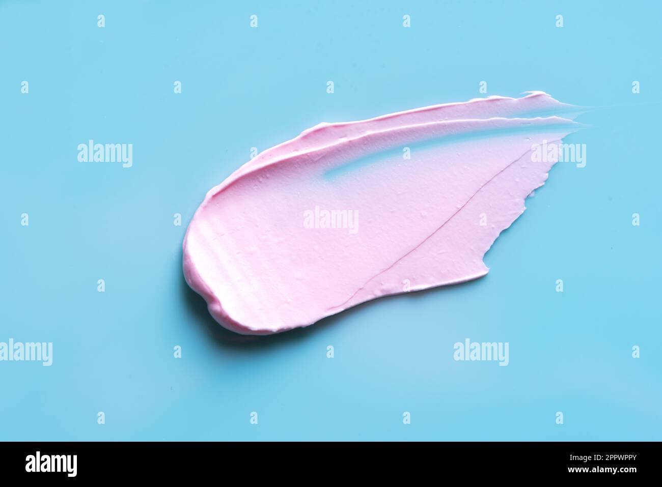Pink cosmetic cream gel sample on blue background. Pink primer cream ...