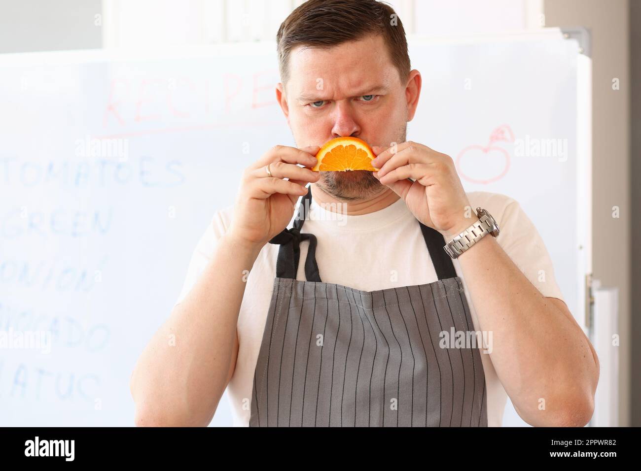 Angry sad male cook with orange slice frown Stock Photo - Alamy