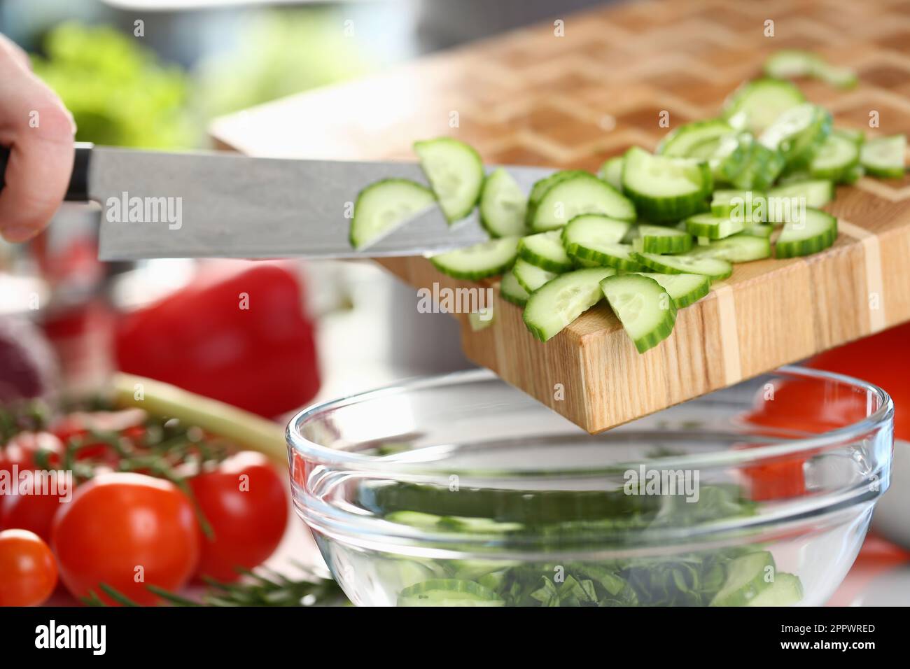 Cook in kitchen at work prepares vegetable salad and cuts green ...