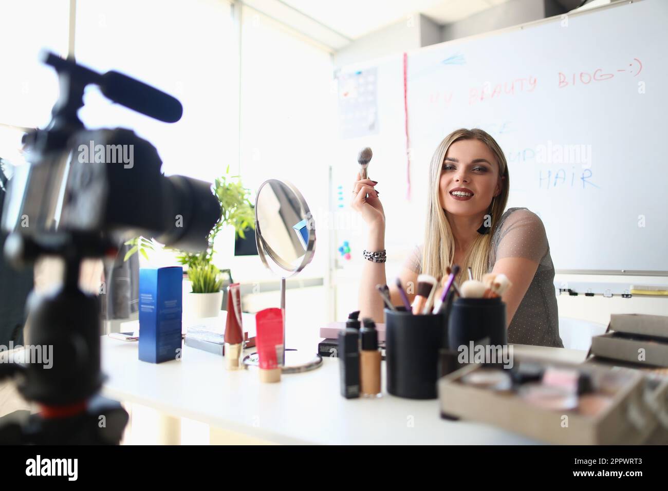 Beautiful woman blogger shows how to apply makeup and use cosmetics ...