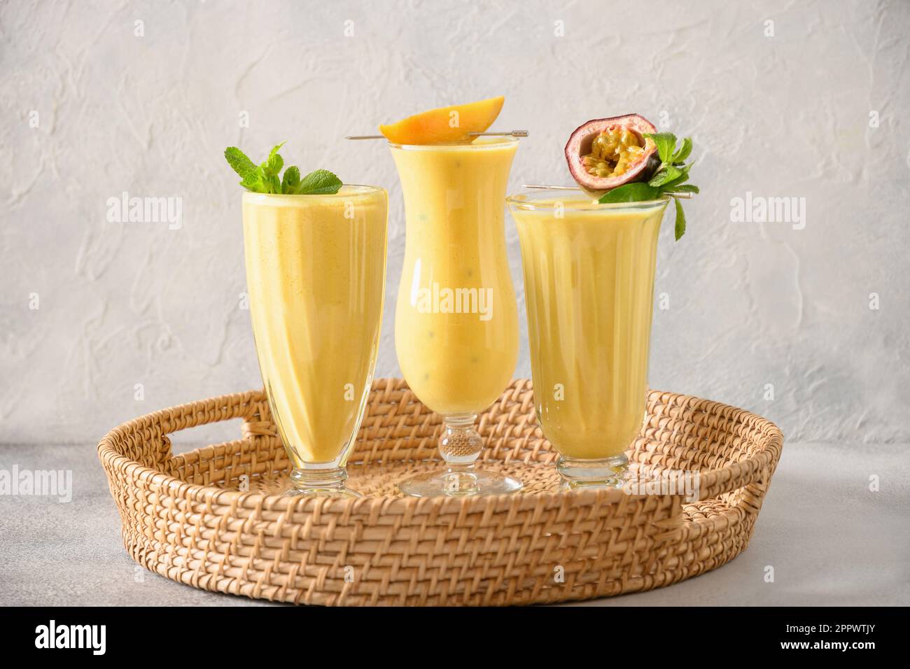 Three tropical passion fruit and mango lassi or milkshake and smoothie ...