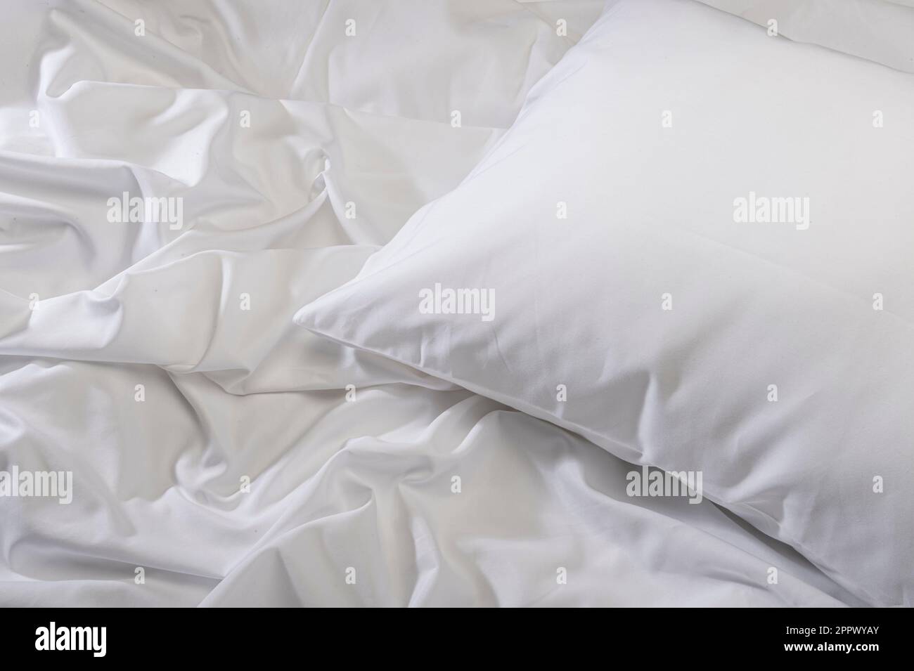 White pillow on bed with wrinkled sheets Stock Photo - Alamy
