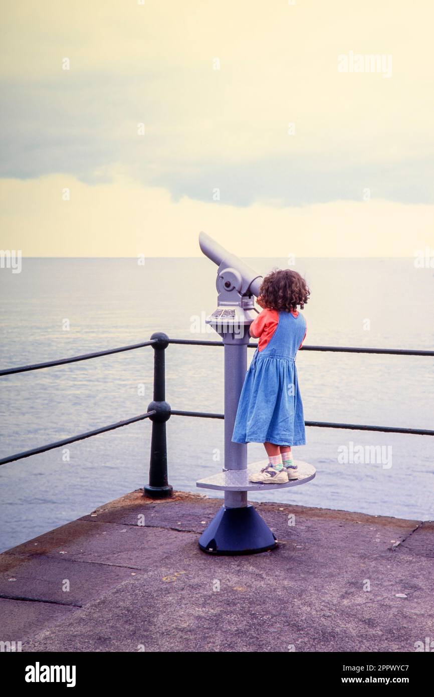 Rear view of a young caucasian child standing on the metal step of a ...