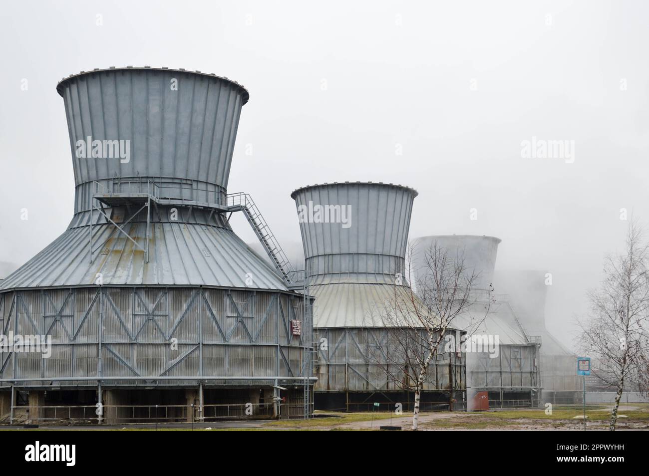 Large cooling towers in water and fog at an oil refinery, petrochemical ...