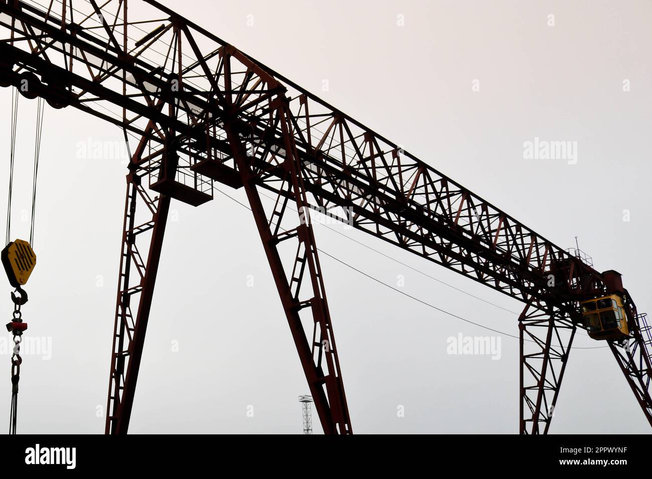 Industrial iron large metal gantry crane with a hook mounted on the ...