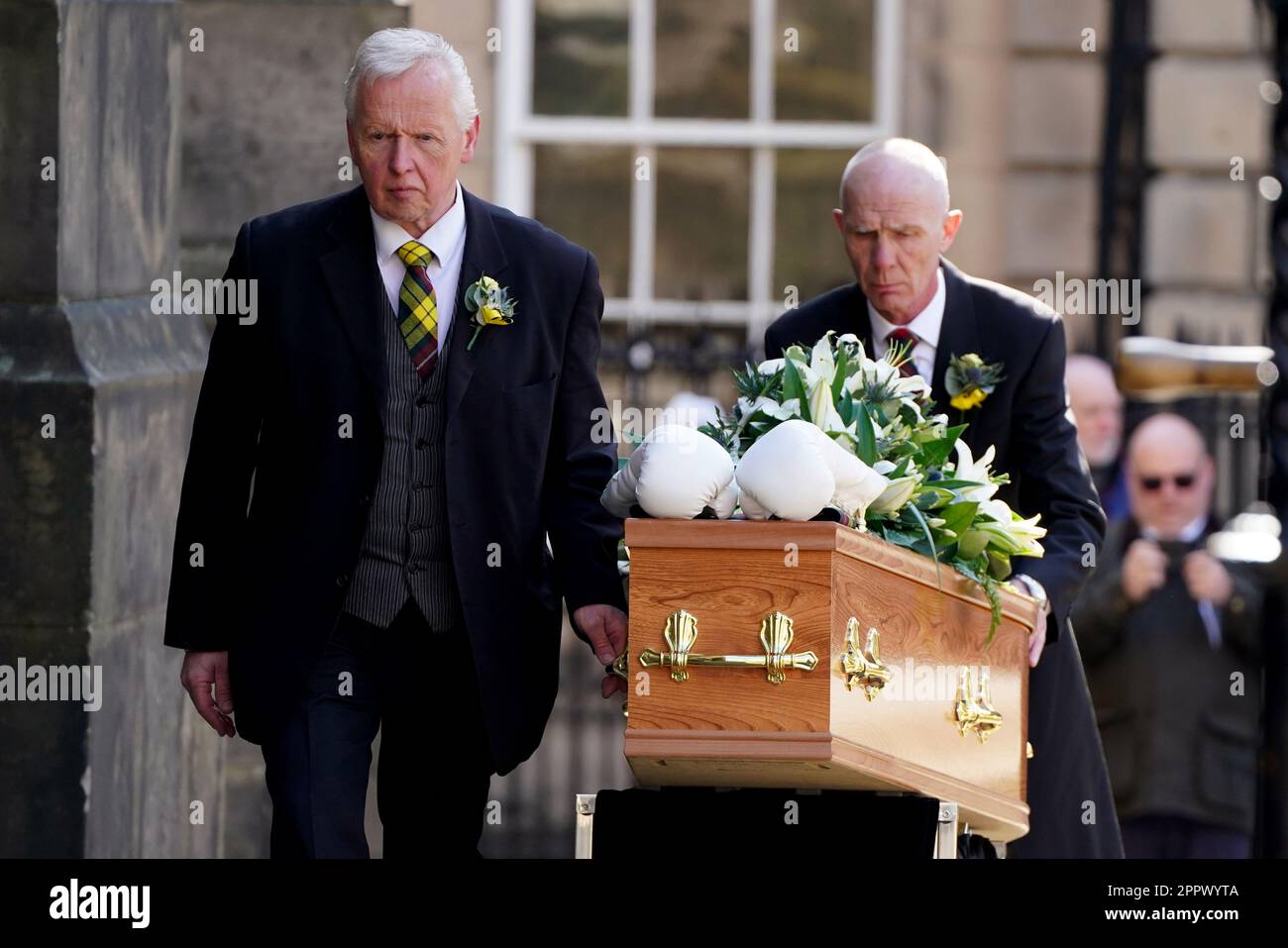 A pair of white boxing gloves rest on the coffin of former boxer Ken ...