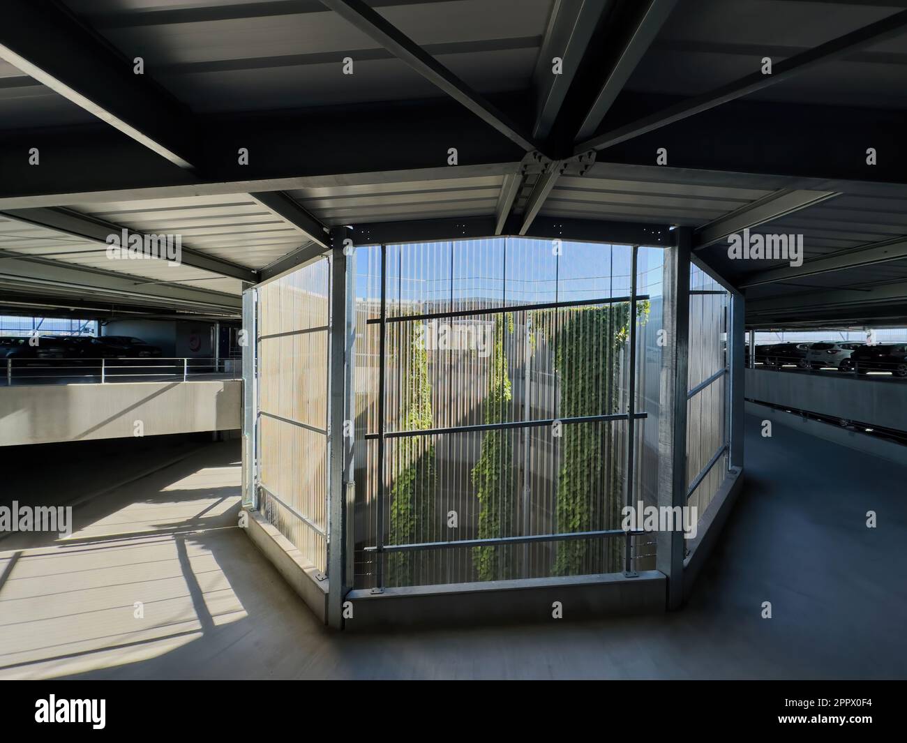 A modern, industrial-style building with a unique spiral access ramp ...