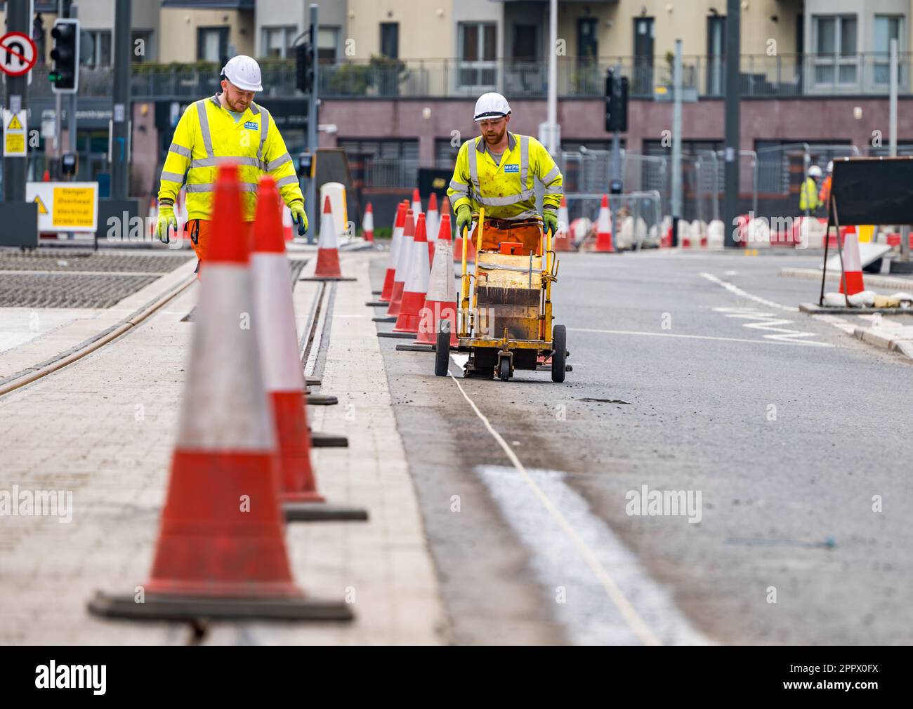 Two workmen painting white lines on roadside next to tram tracks, Leith ...