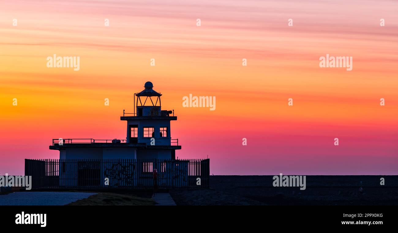 Lighthouse silhouetted at sunrise, entrance to Leith Harbour dockyard ...