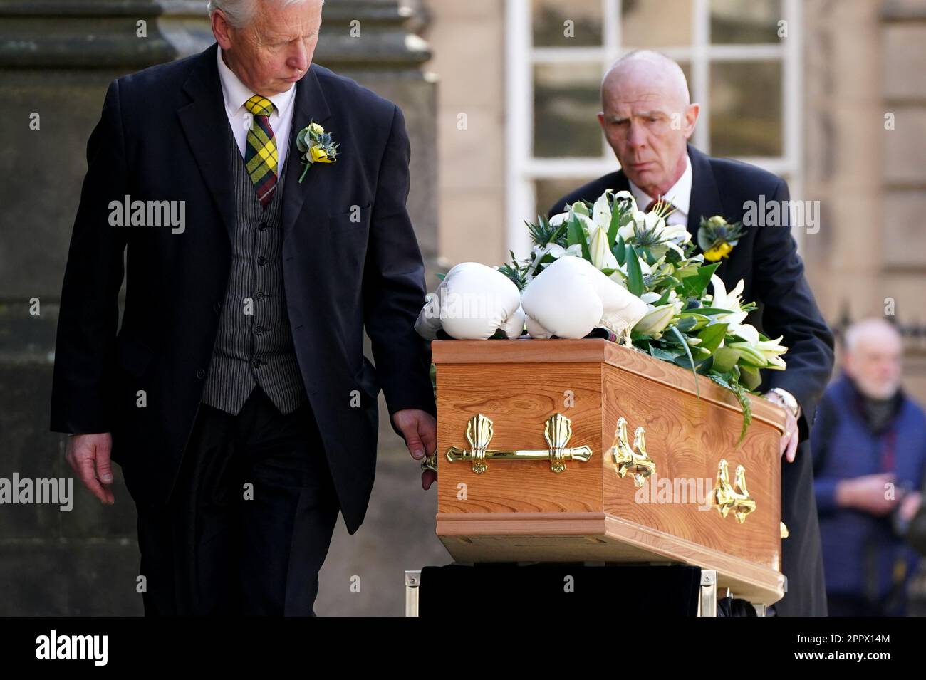 A pair of white boxing gloves rest on the coffin of former boxer Ken ...