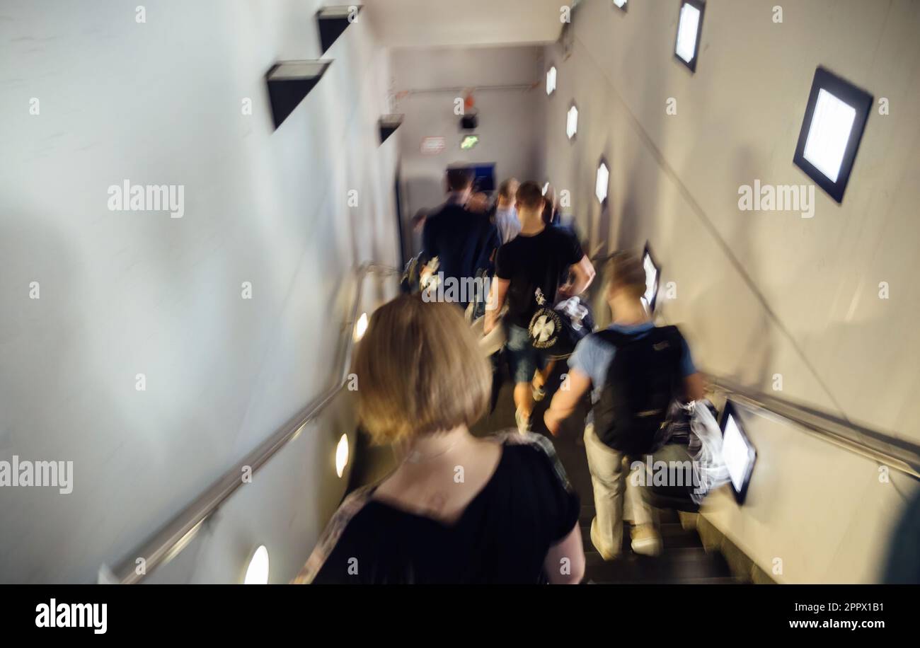 A bustling group of passengers, both men and women, are seen descending ...
