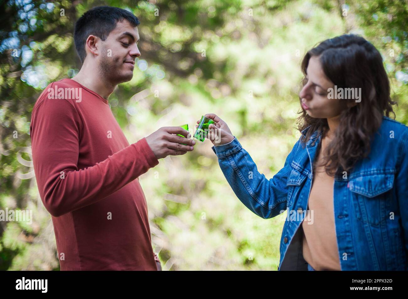 Cheers. Very drunk couple, a boy and a girl, chug shot drink from small ...