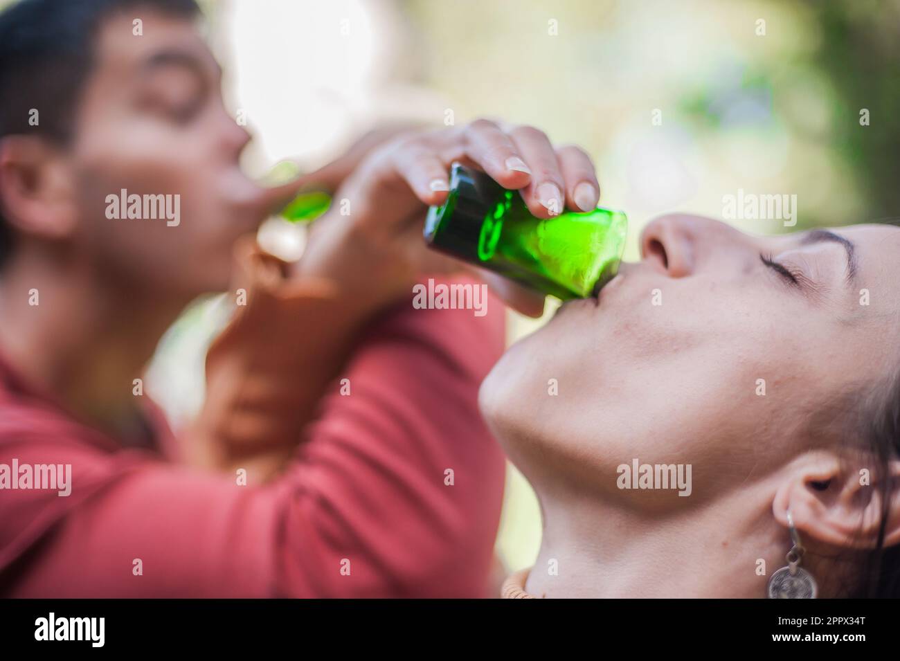 Cheers. Very drunk couple, a boy and a girl, chug shot drink from small ...