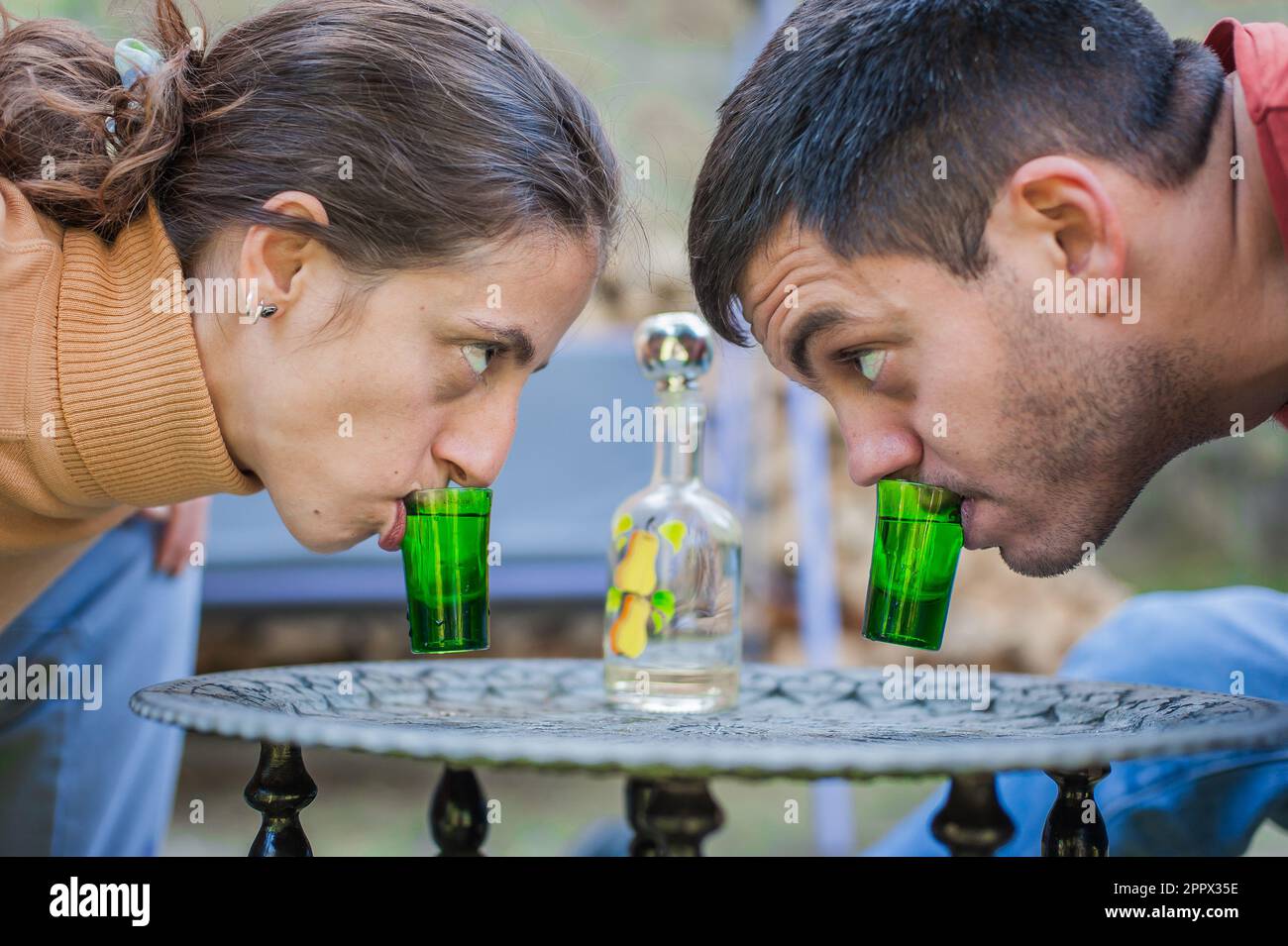 Cheers. Very drunk couple, a boy and a girl, chug shot drink from small ...