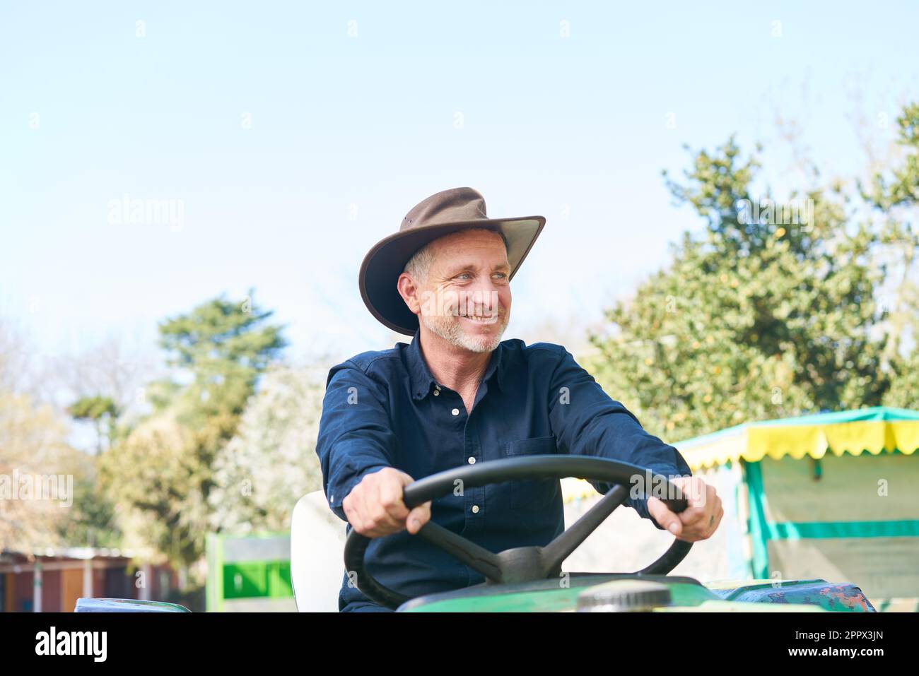 Happy farmer driving tractor on farm in summer Stock Photo - Alamy