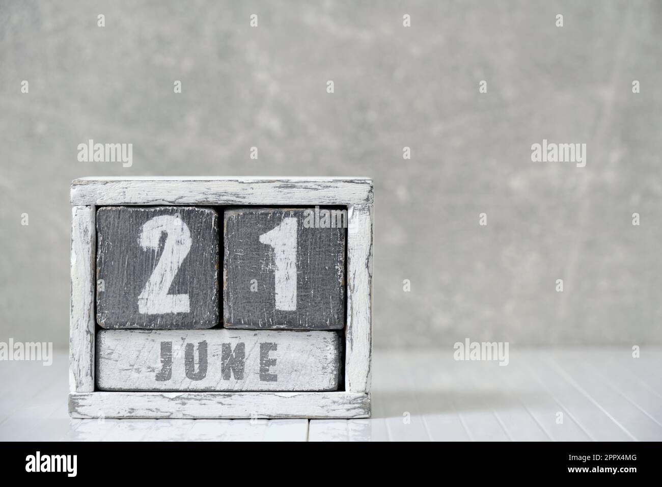Calendar for June 21, made wooden cubes, against light concrete wall ...