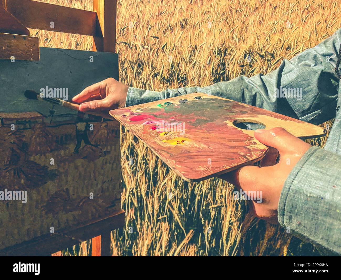 the artist paints on canvas. in the hands of the artist a brush and a ...