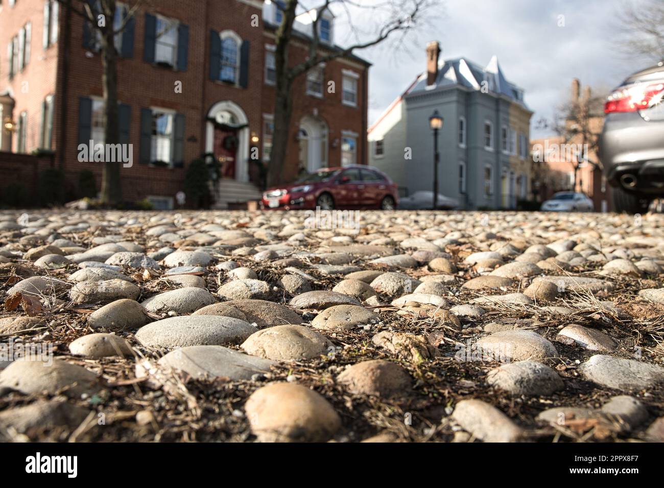 A wide cobblestone street with houses on the background Stock Photo - Alamy