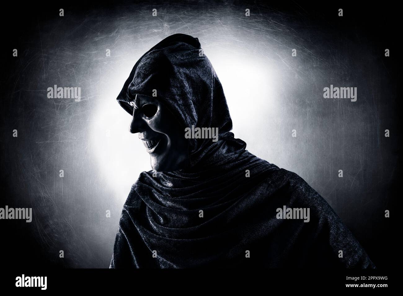 Scary figure with hooded cloak in the dark Stock Photo - Alamy
