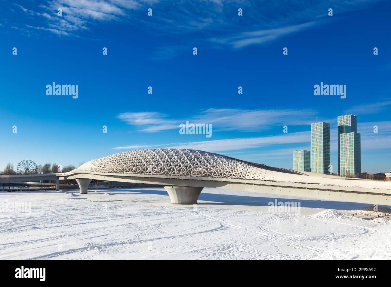 Contemporary pedestrian Atyrau Bridge over Ishim river in winter ...