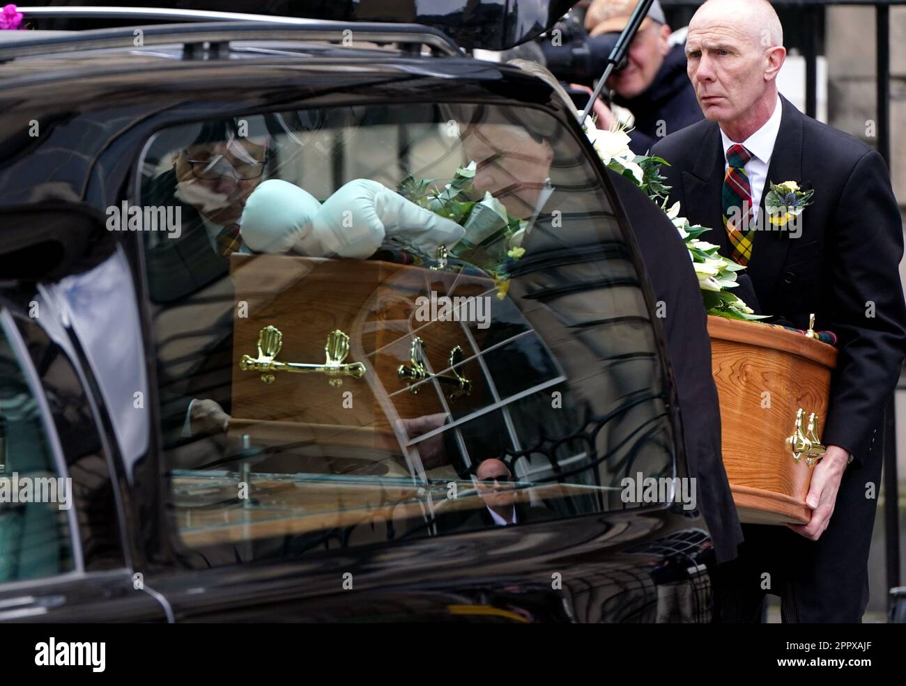 A pair of white boxing gloves rest on the coffin of former boxer Ken ...