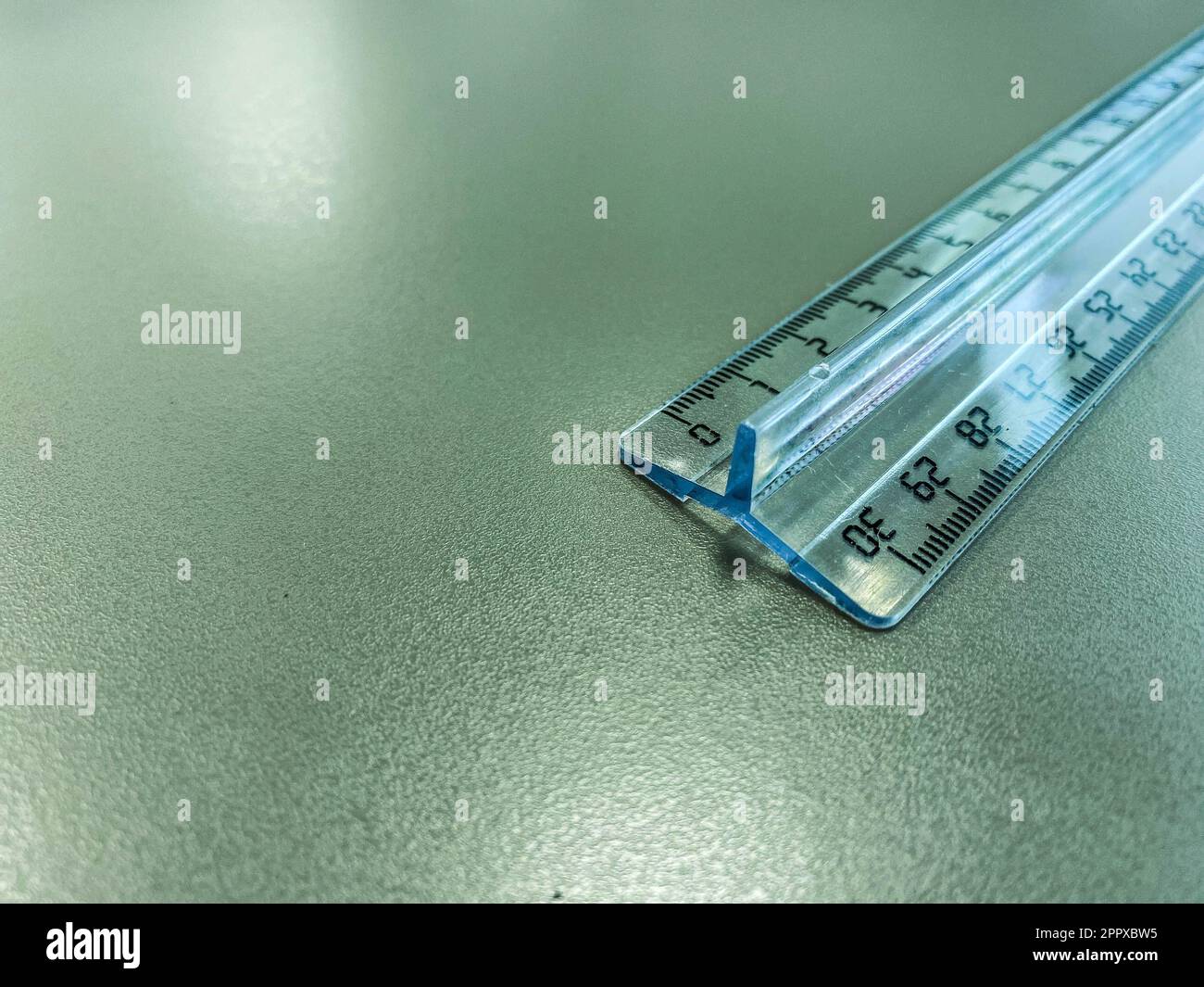 a transparent, long, centimeter ruler lies on the table. supplies for ...