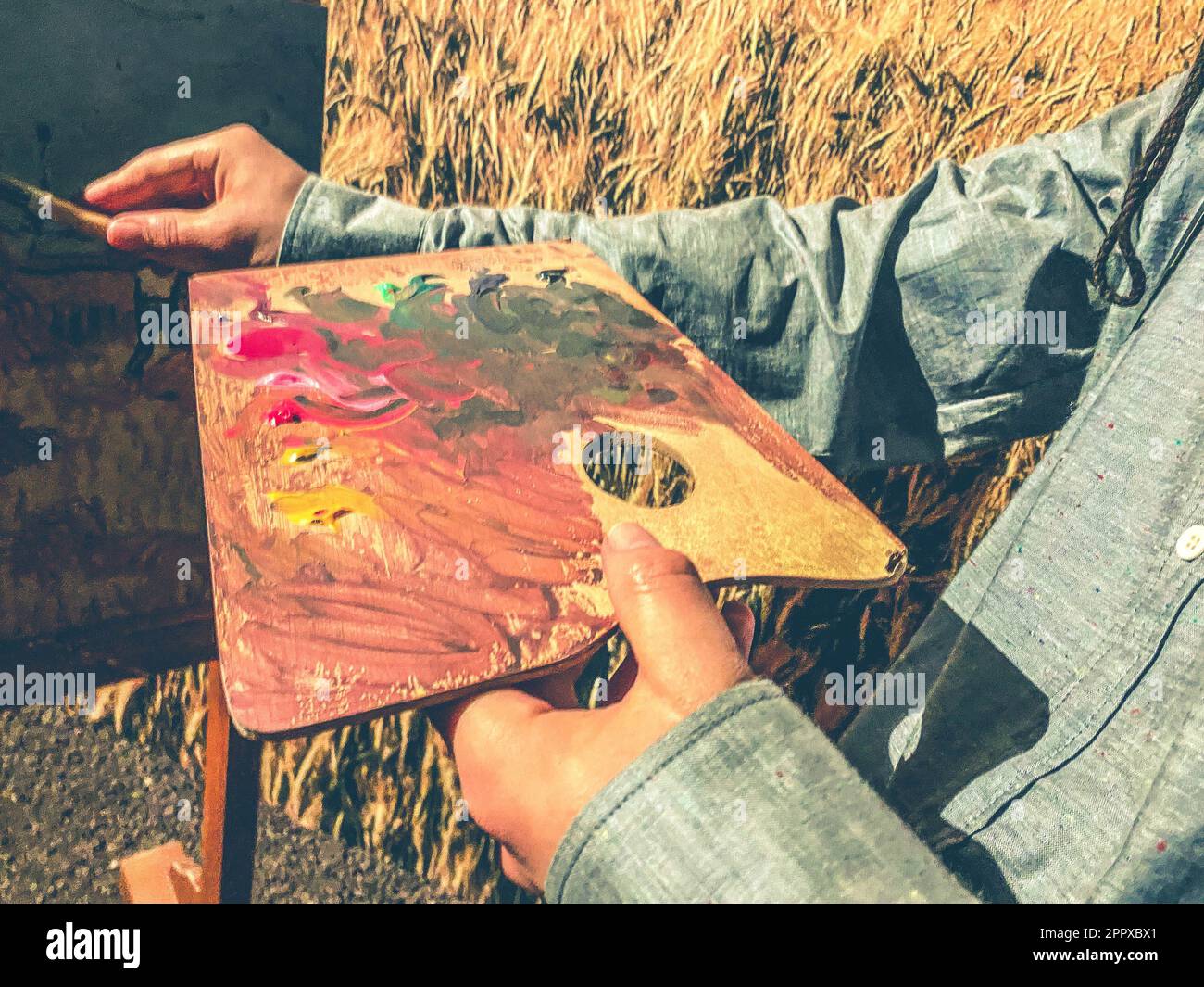 the artist paints on canvas. in the hands of the artist a brush and a ...