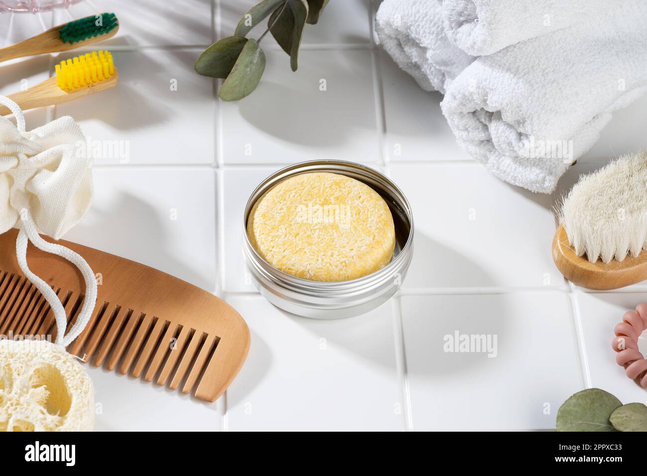 Sustainable solid shampoo bar and bathroom accessories lying on a white ...