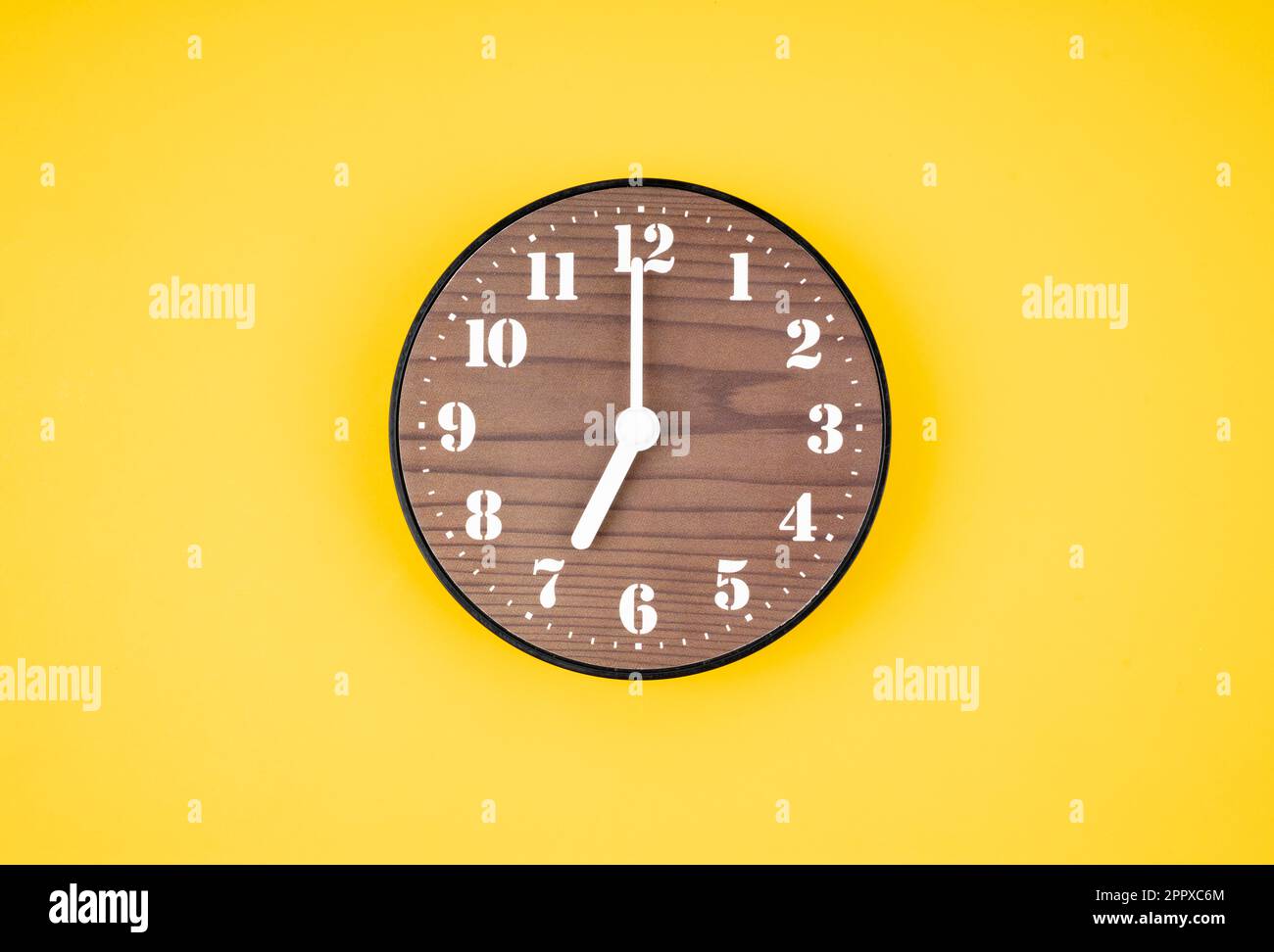 Retro wooden clock at 7 O' clock on yellow color background Stock Photo ...