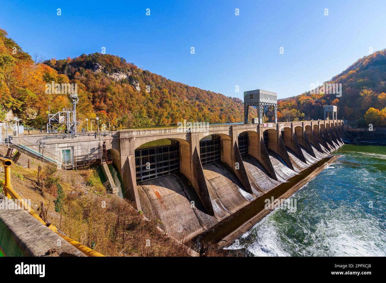 A majestic view of a dam spillway on the side of a mountain, with the ...