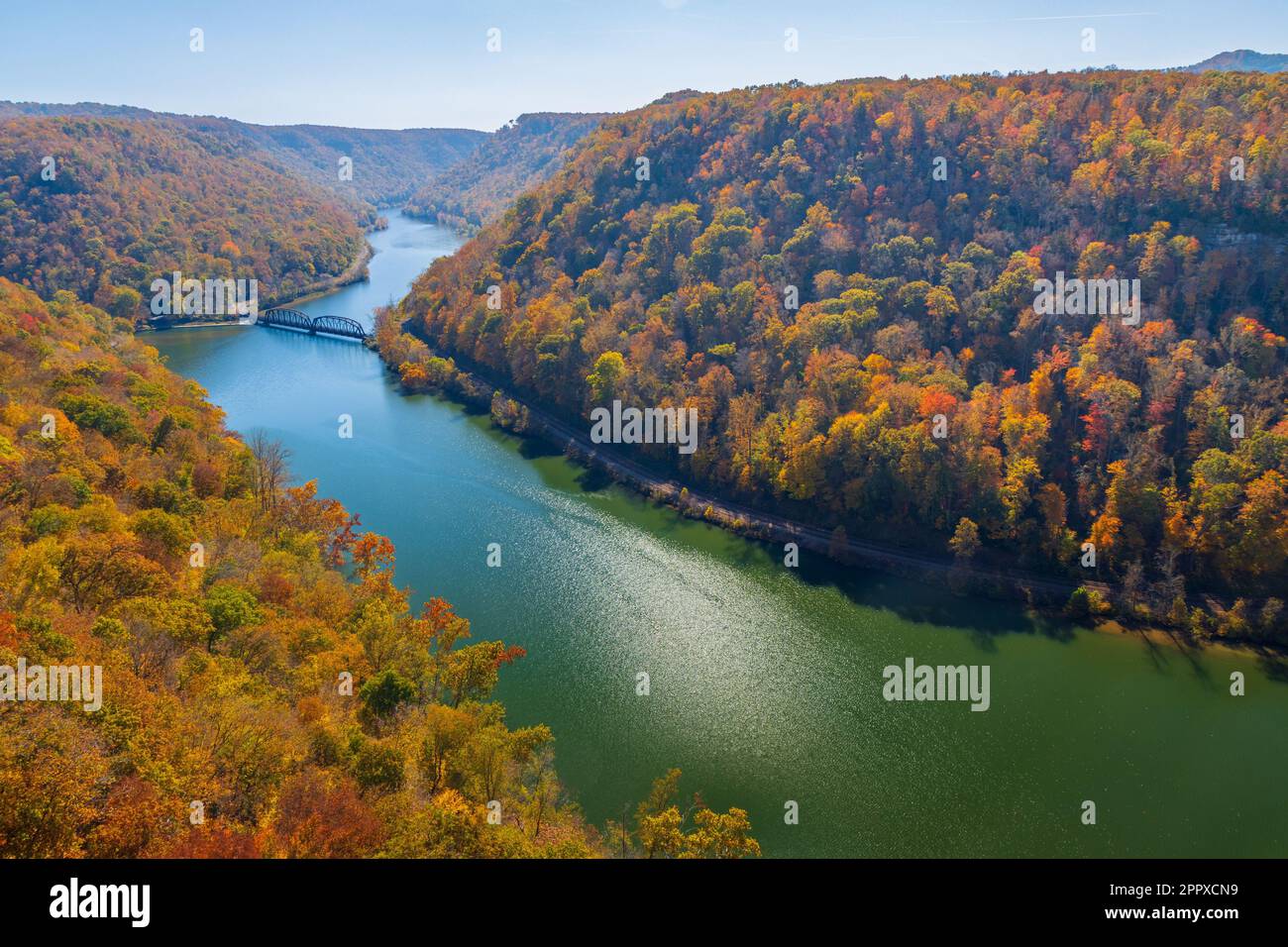A scenic landscape of a large river surrounded by lush vegetation ...