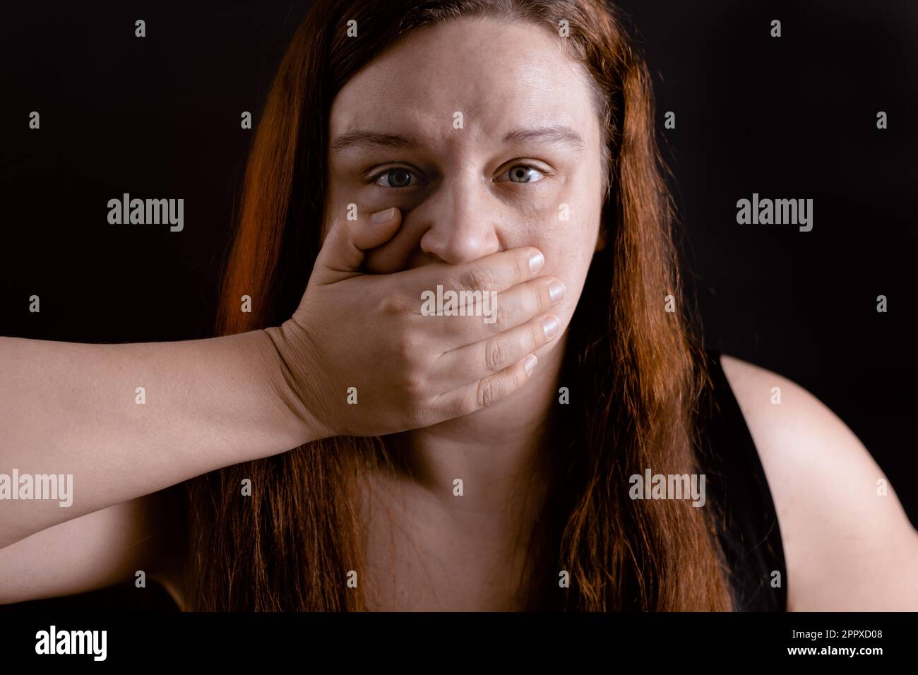 Unhappy young woman closing mouth with hand. Upset girl suffering ...