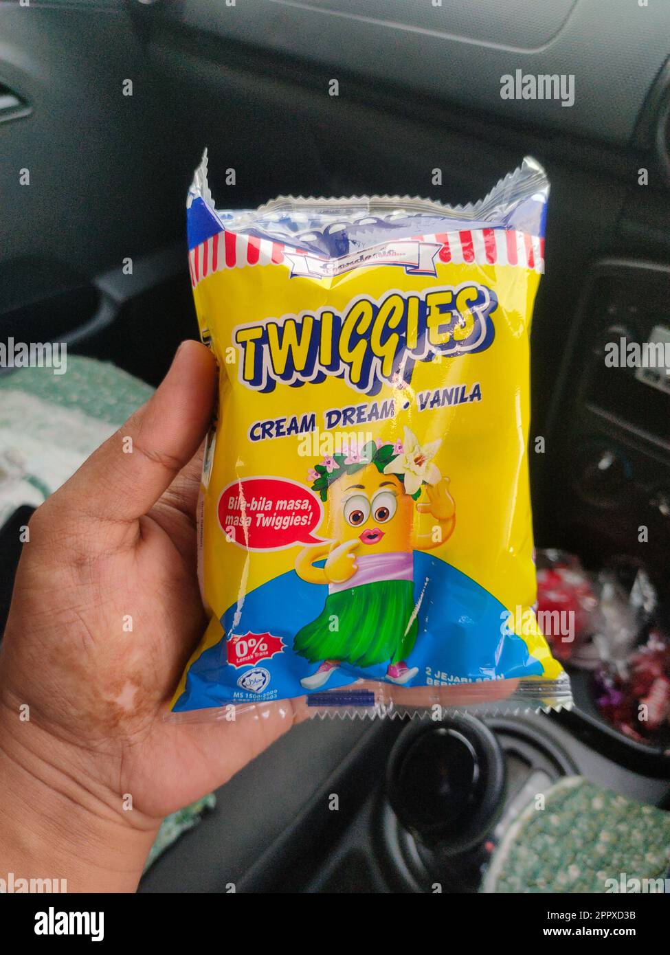 Malaysia, 25 May 2022: Hand holding plastic Gardenia Twiggies cream ...