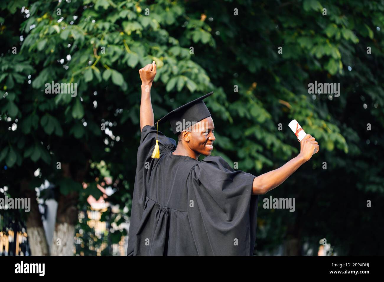 Portrait back view of happy black man graduate from university stand ...