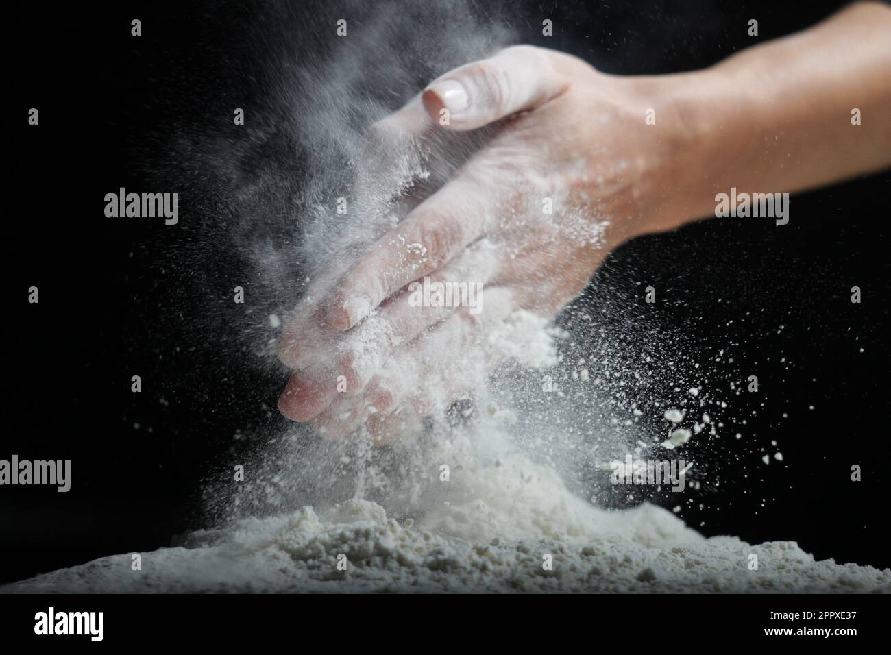 Female hands sift flour with a metal sieve on a black background Stock ...