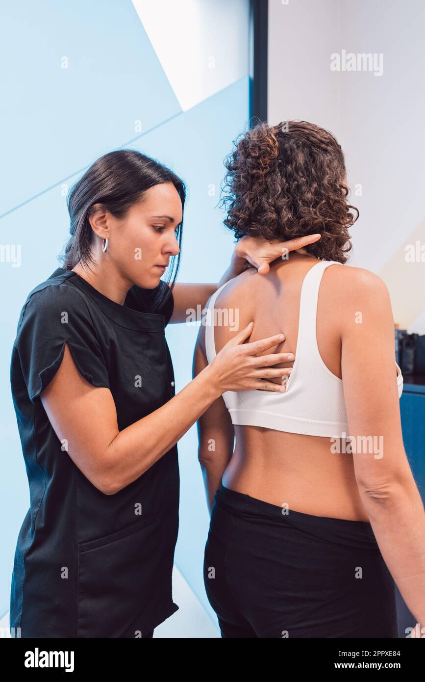 Side view of focused female doctor standing behind unrecognizable ...