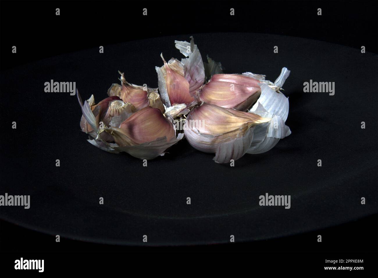 Open garlic on black background table Stock Photo - Alamy